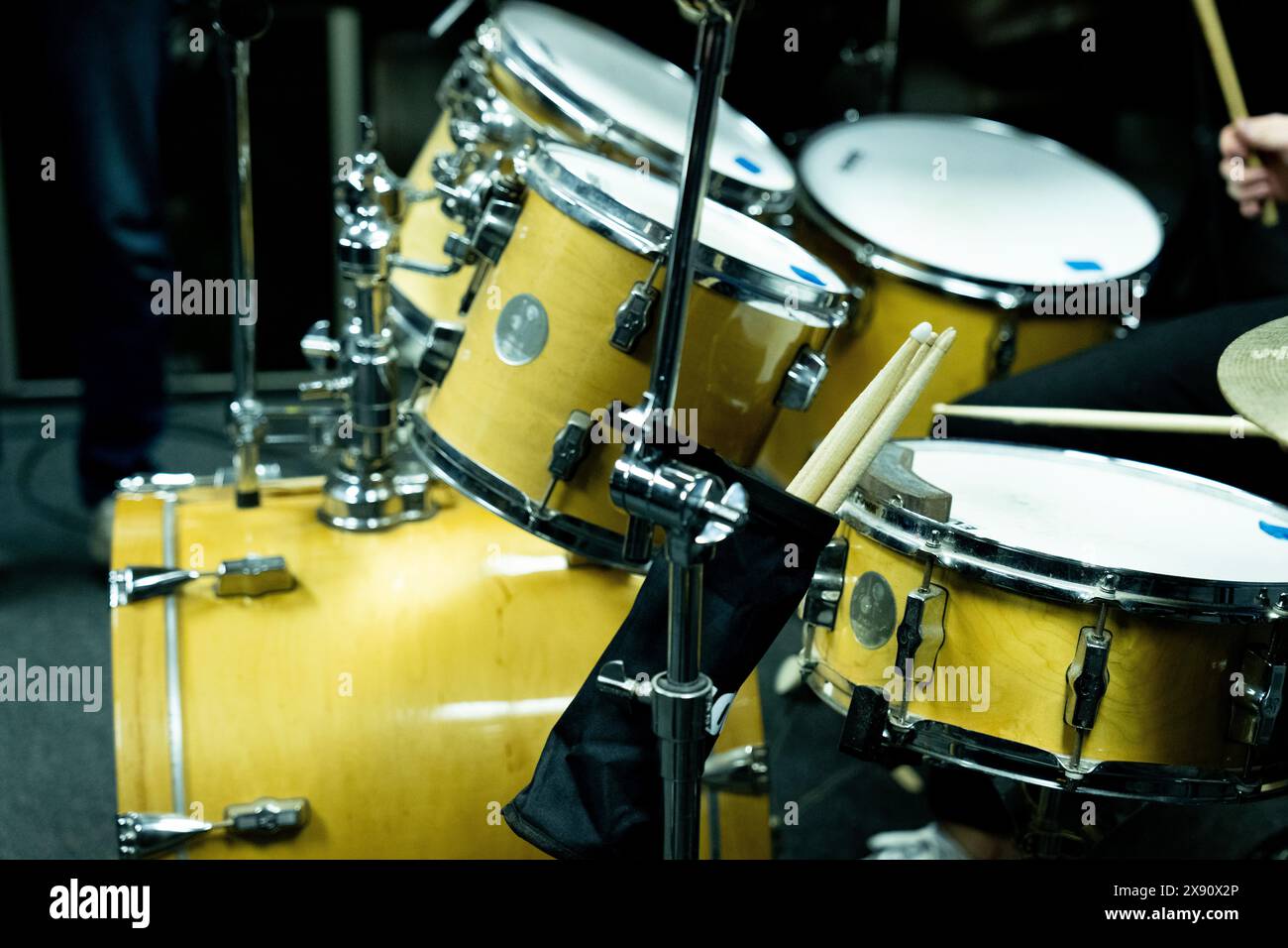 Side view of a yellow drum kit with drumsticks Stock Photo - Alamy