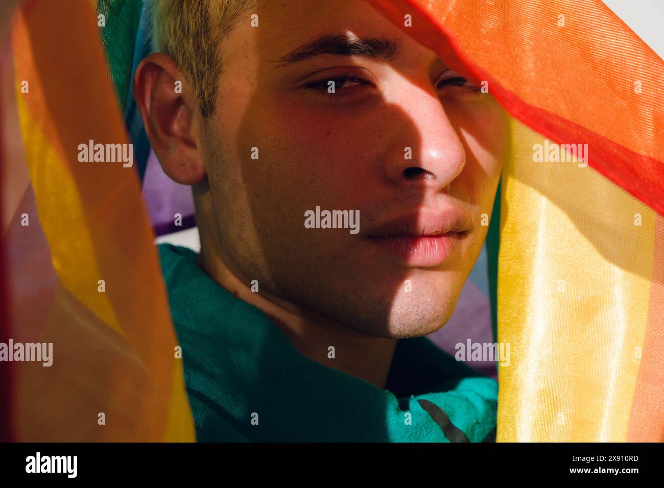 closeup of a Young Latin Man behind shadow of gay pride flag. Concept ...