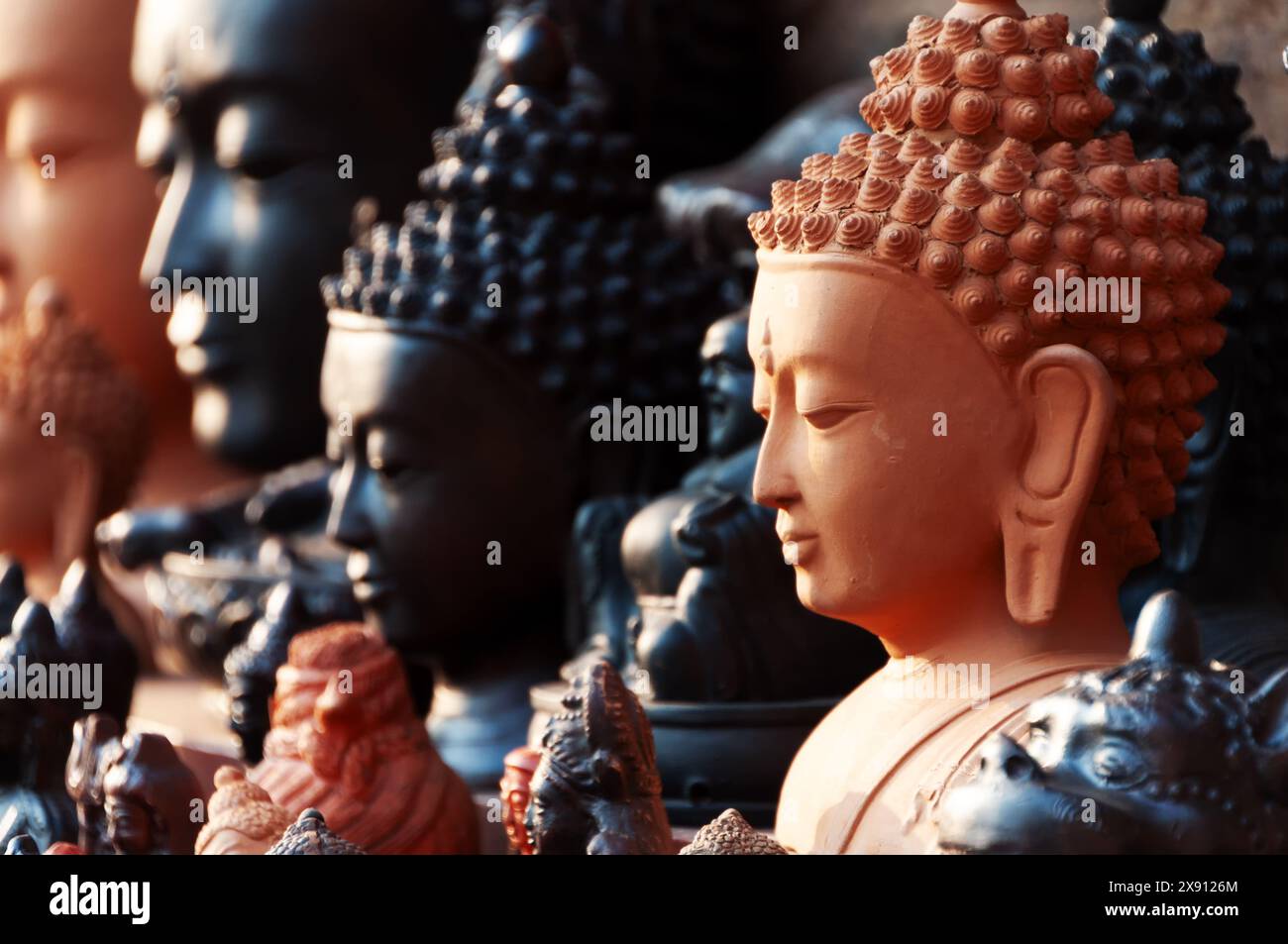 Side view of clay Buddha faces sale display in Katmandu Stock Photo - Alamy