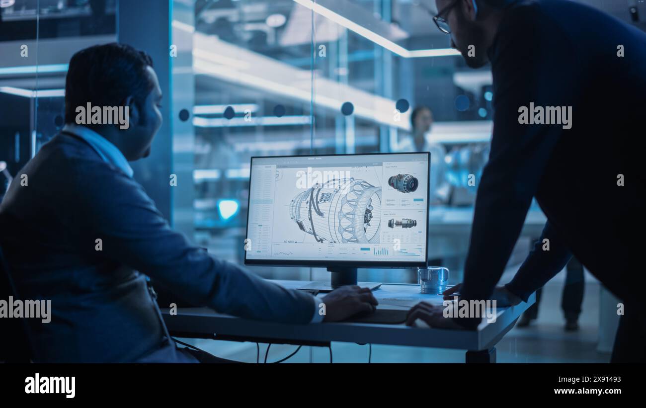 Two Industrial Engineers Discussing Work Projects, Talk and Use Desktop ...