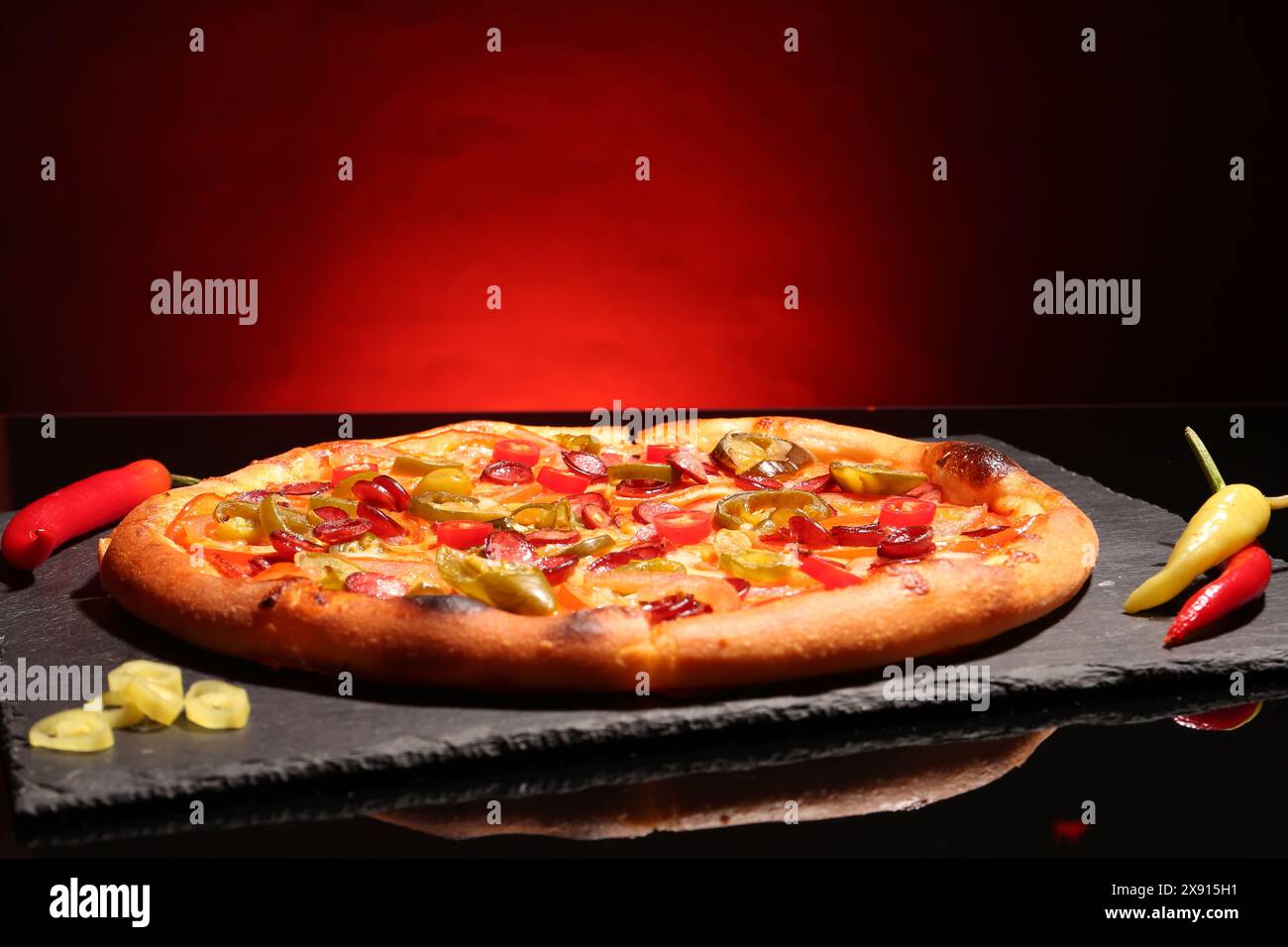 Delicious pizza Diablo on slate board against red background Stock ...