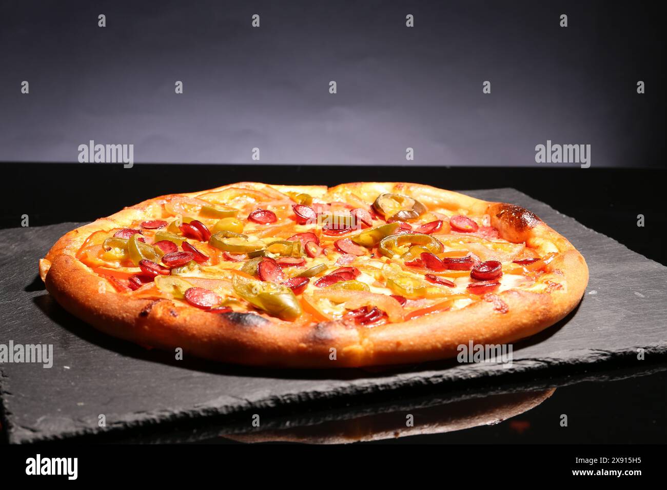 Delicious pizza Diablo on slate board against grey background Stock ...
