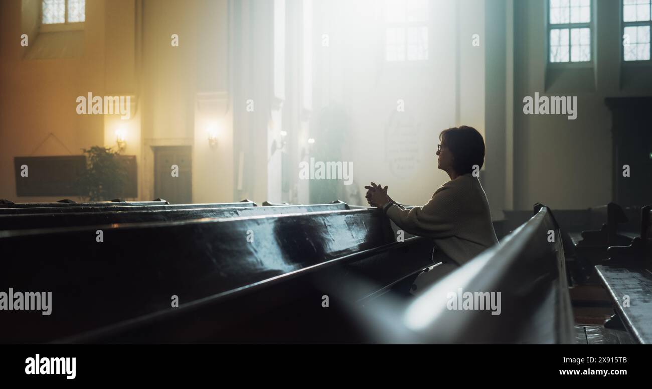 A Devout Christian Older Woman Sits Piously In a Church, Folding Hands ...