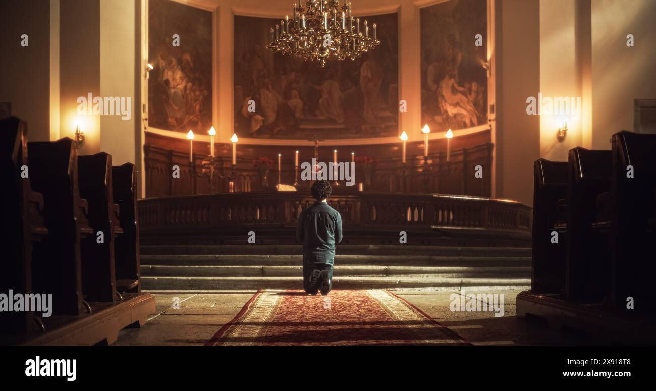 Back View: Christian Man Getting on his Knees and Starting to Pray in a ...