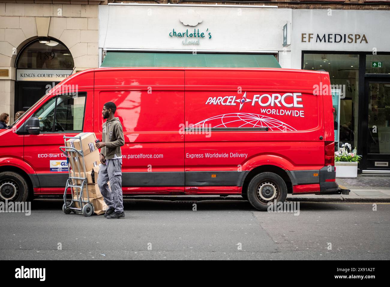 LONDON- MAY 23, 2024: Parcelforce Worldwide delivery driver and van, a ...