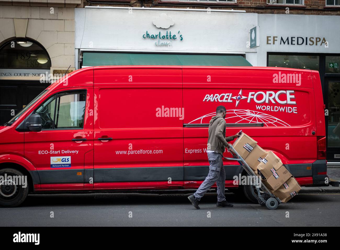 LONDON- MAY 23, 2024: Parcelforce Worldwide delivery driver and van, a ...