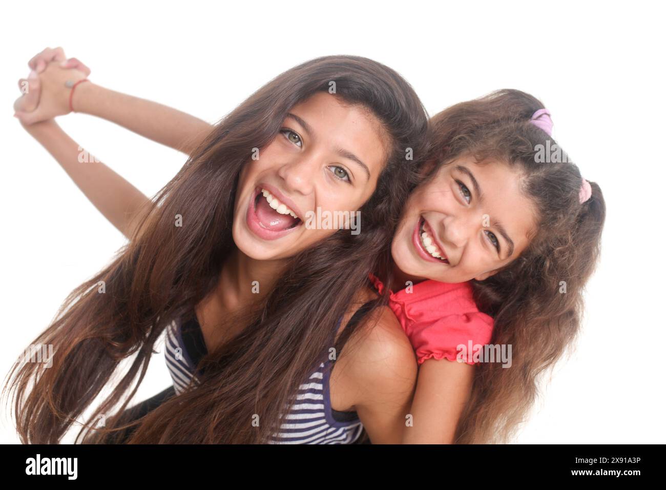 portrait of two cheerful hispanic girls laughing white background Stock ...