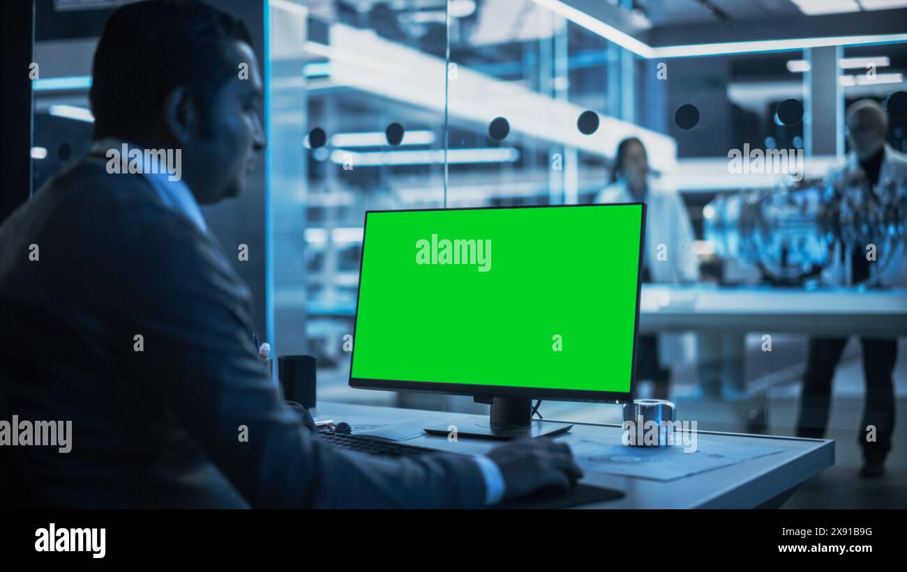 Software Developer Working on Computer with Green Screen Mock Up Display. Scientific Lab ...