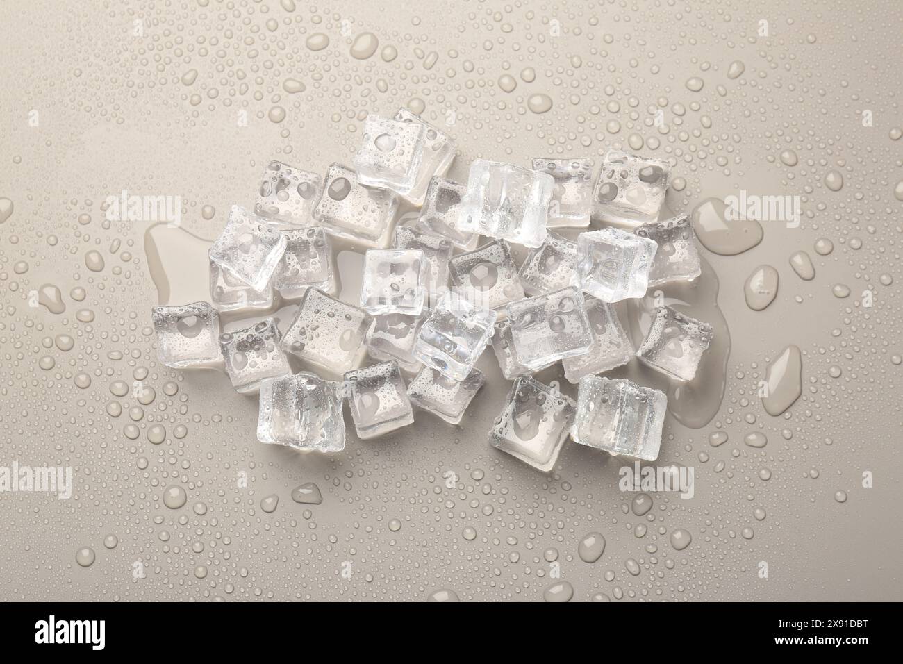 Pile of melting ice cubes and water drops on light grey background ...