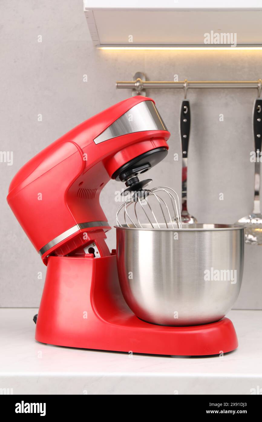Modern red stand mixer on white table in kitchen Stock Photo - Alamy