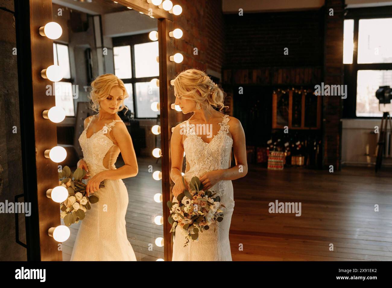 Bride in a wedding dress holding a bouquet, gazing at her reflection in ...