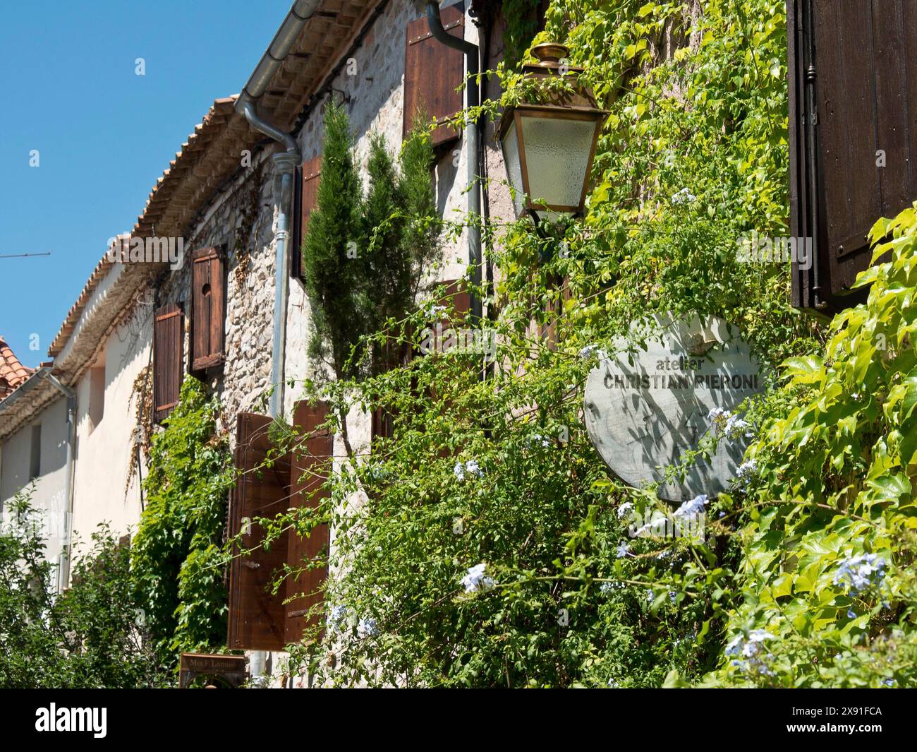 Stone walls with ivy-covered walls, lantern and sign in sunny weather ...