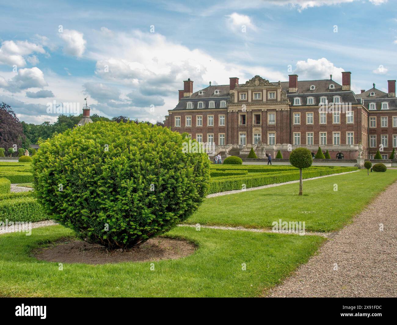 Well-kept symmetrical garden with hedges and paths in front of a ...