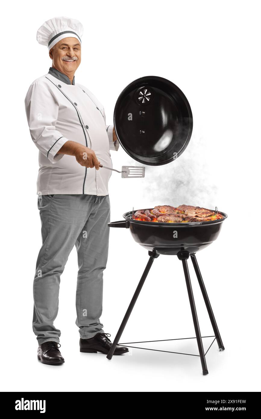 Chef grilling meat on a bbq and smiling isolated on white background ...
