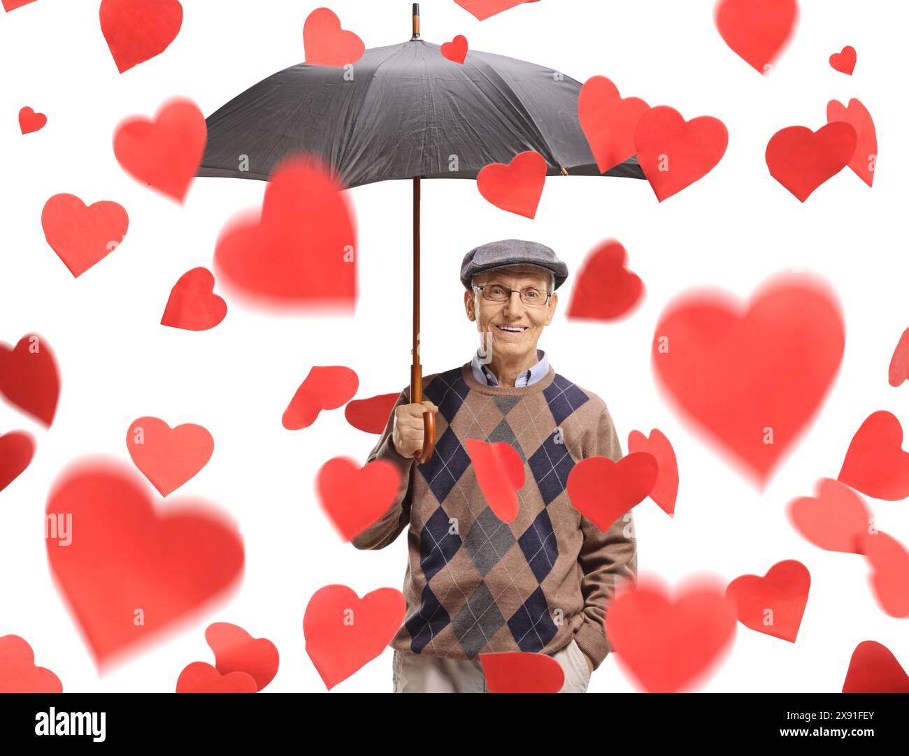 Hearts falling above a senior man with an umbrella isolated on white ...