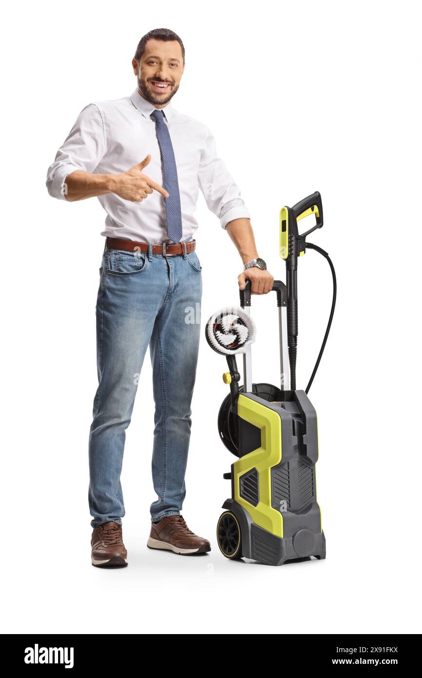 Young man pointing at a high pressure washer machine isolated on white ...