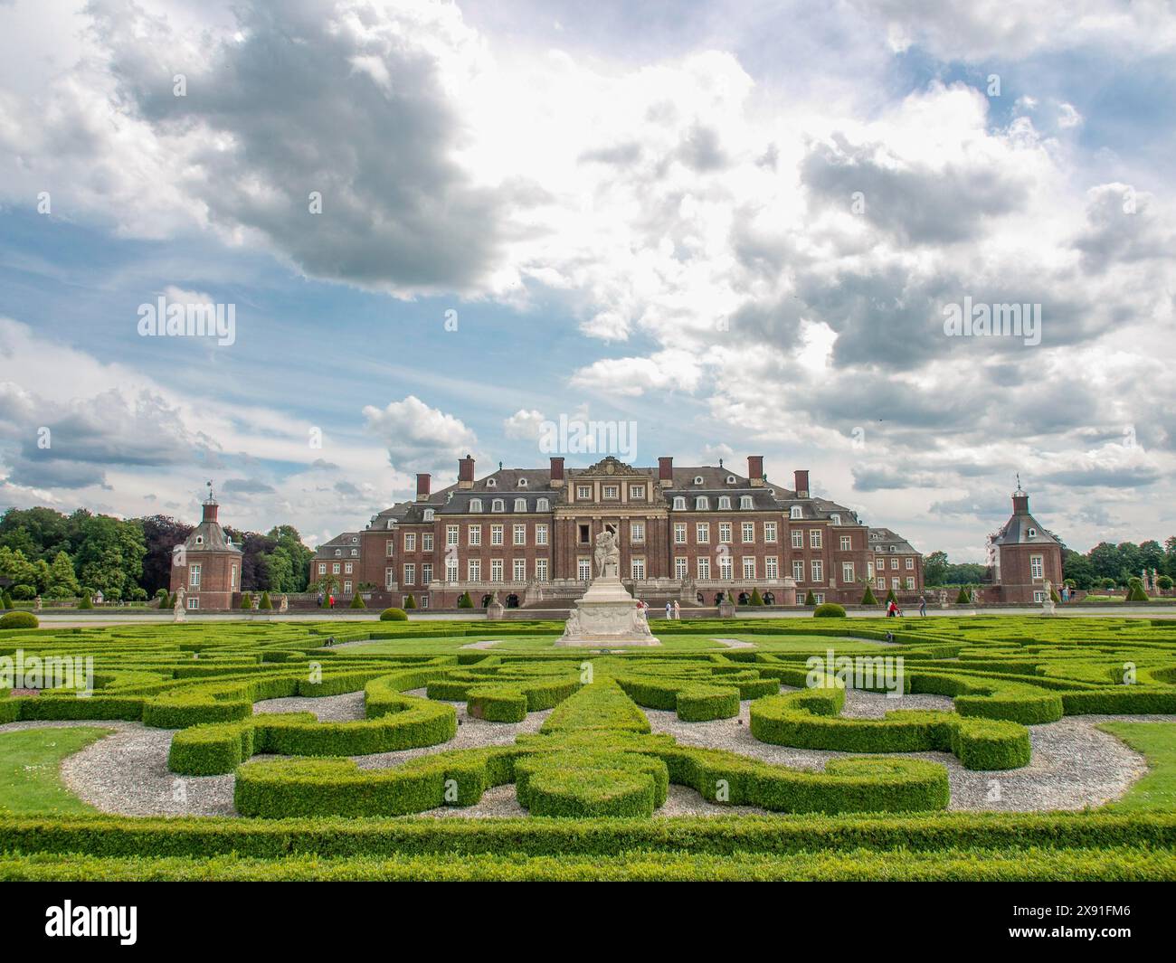 A large historic castle surrounded by a symmetrical garden with ...