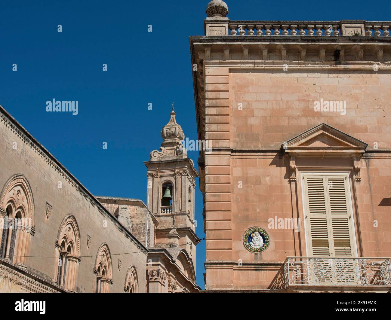 Historic buildings with church tower and shutters under blue sky, old ...