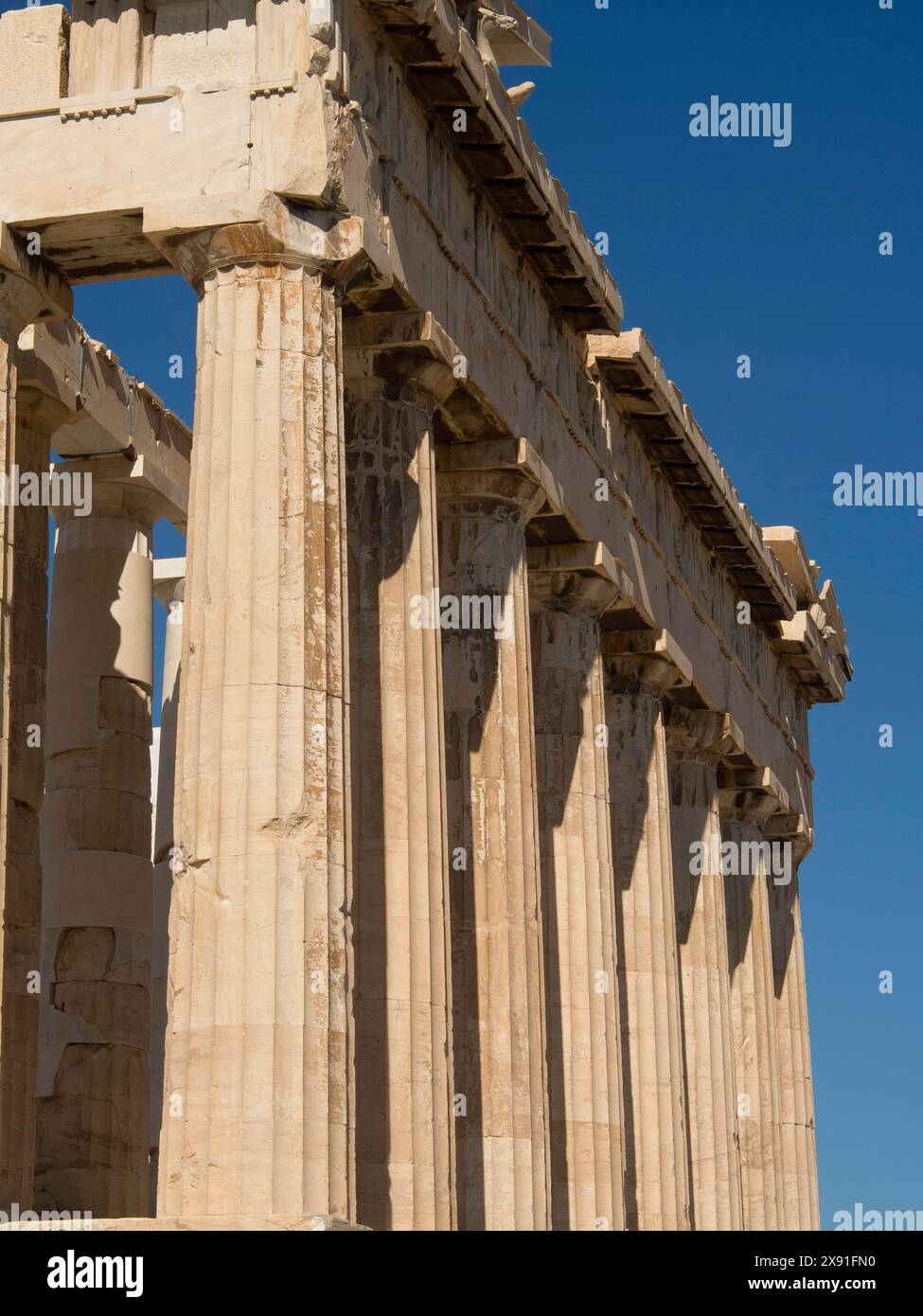 Ancient temple with doric columns under a clear blue sky, ancient columns in front of a blue sky ...