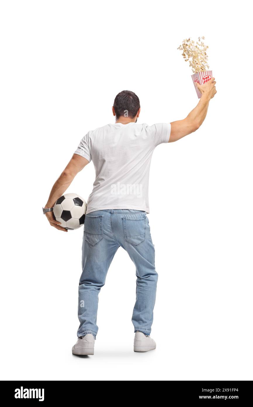 Rear view shot of a happy young man cheering with popcorn and football ...
