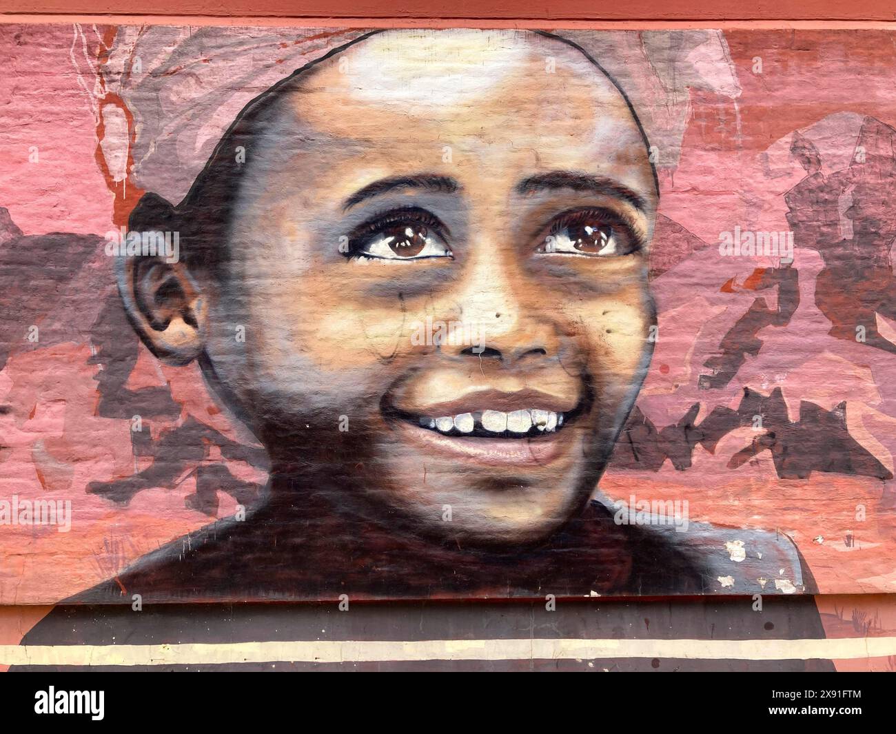 Street art mural showing a smiling face of a dark-skinned girl ...
