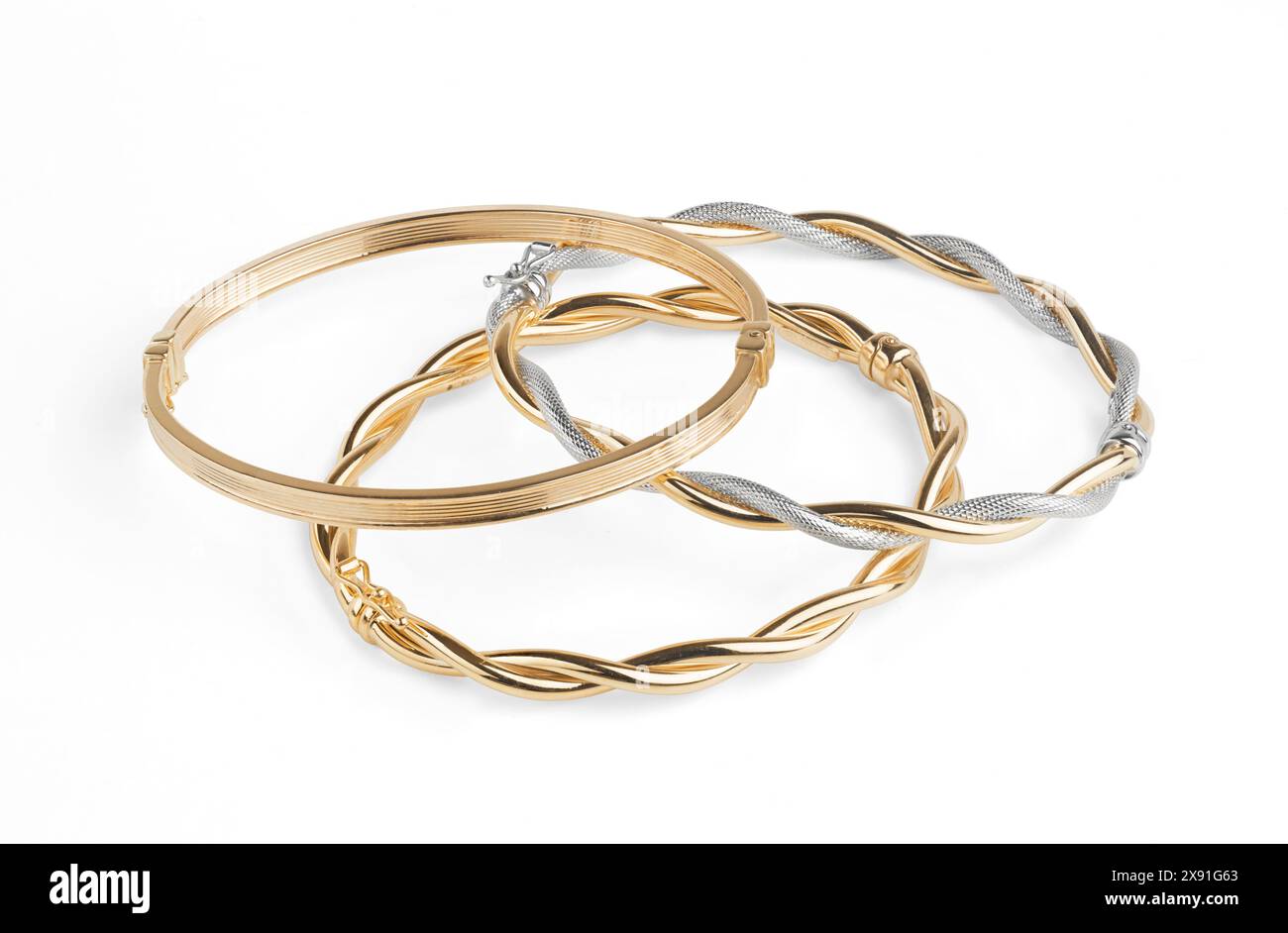 Three 9ct gold different style bangles on a white background Stock ...