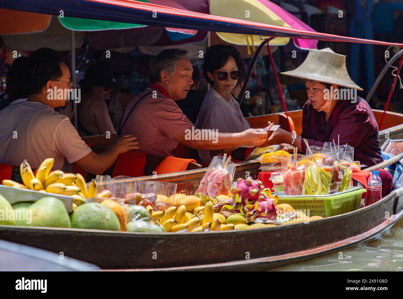 A picture of a saleswoman and customers at the Damnoen Saduak Floating ...