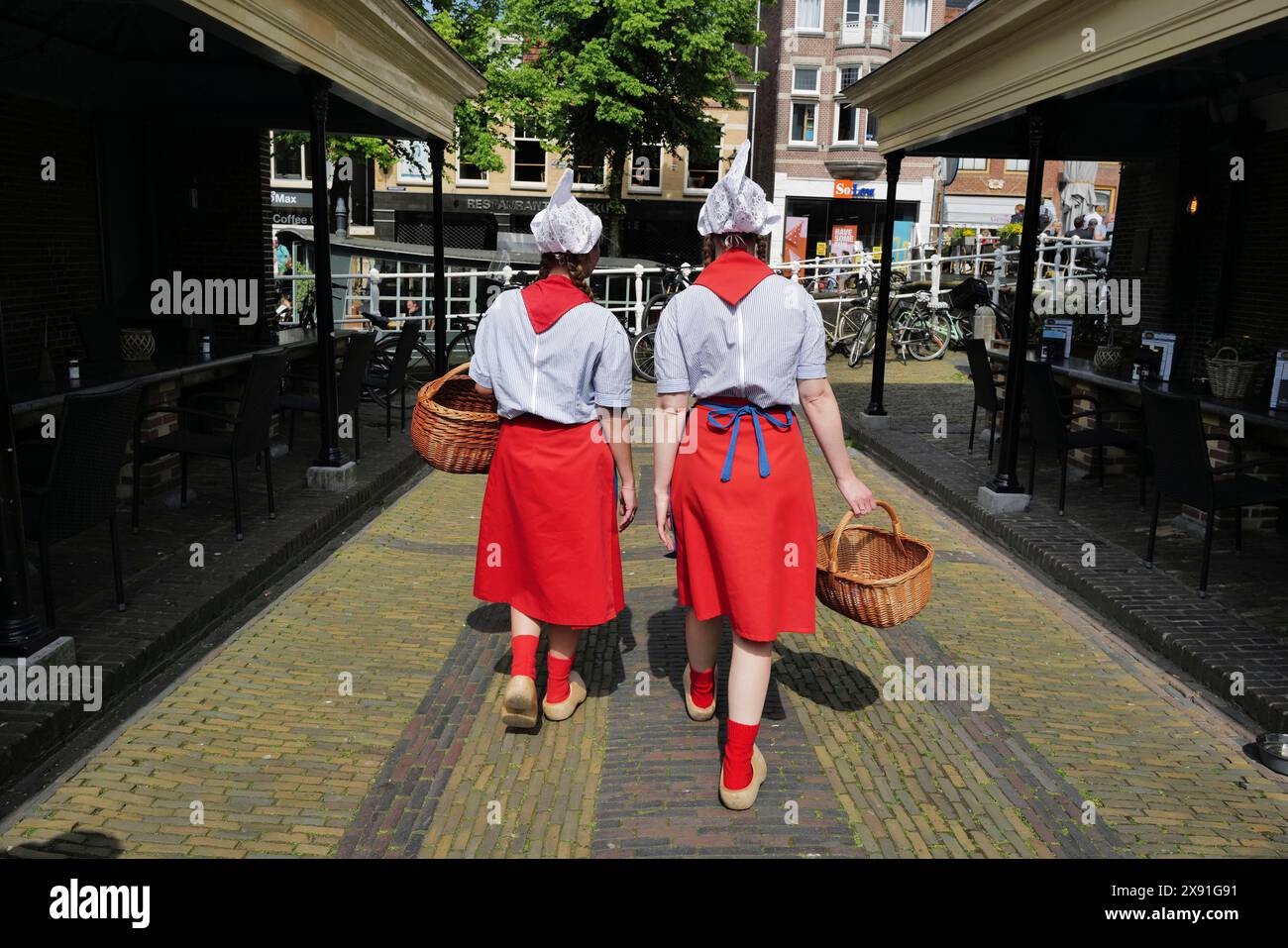 Two Dutch cheese girls in traditional tracht and carrying baskets of ...