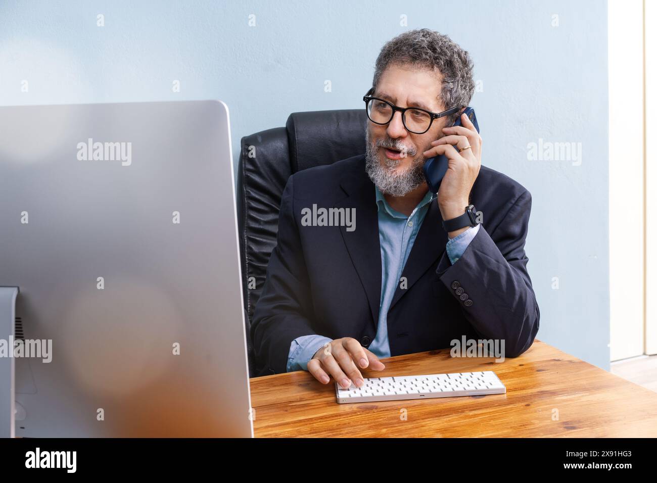 A professional businessman talking on the phone while working at a ...