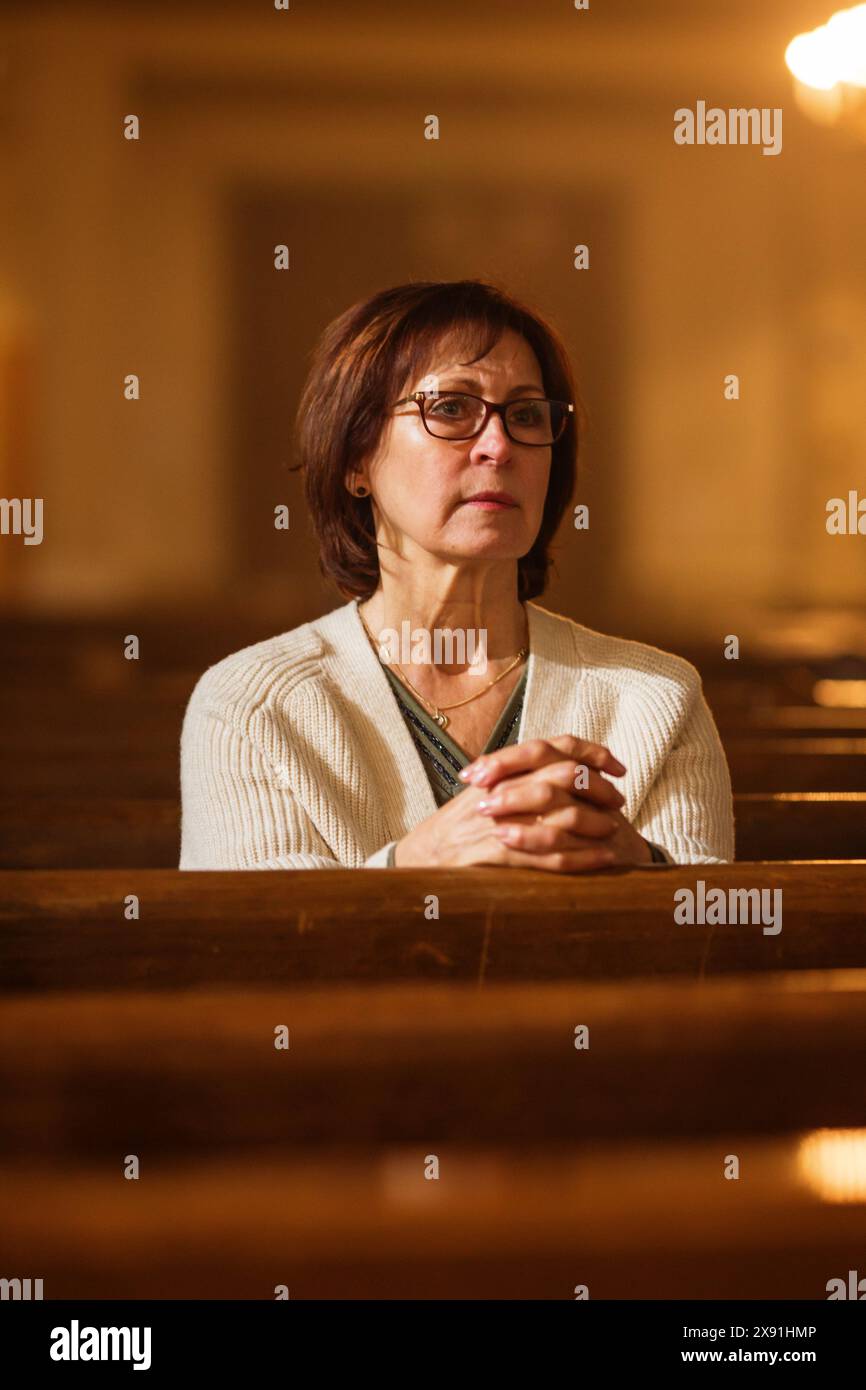 A Devout Senior Christian Woman Sits Piously In a Church, Seeks ...