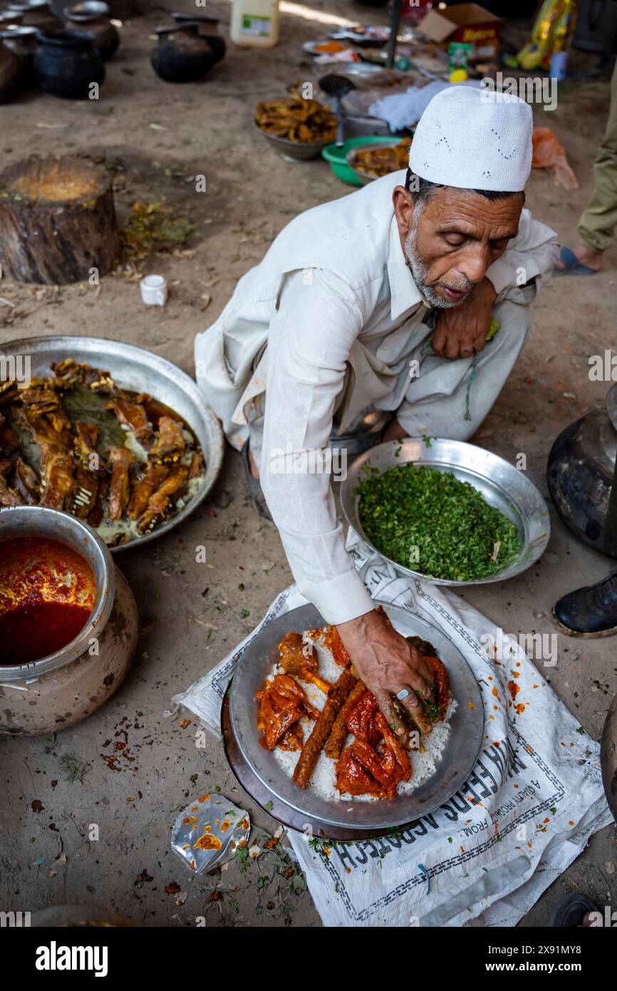 A traditional Kashmiri chef prepares a copper platter (trami) with ...