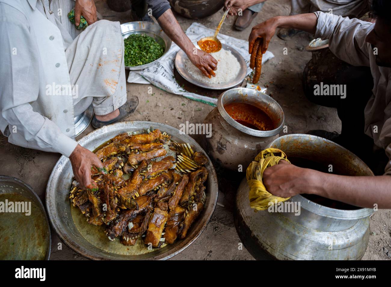 A traditional Kashmiri chef prepares a copper platter (trami) with rice ...