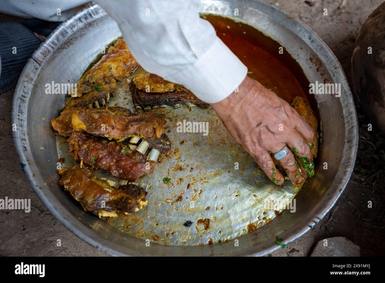 A traditional Kashmiri chef prepares a copper platter (trami) with rice ...
