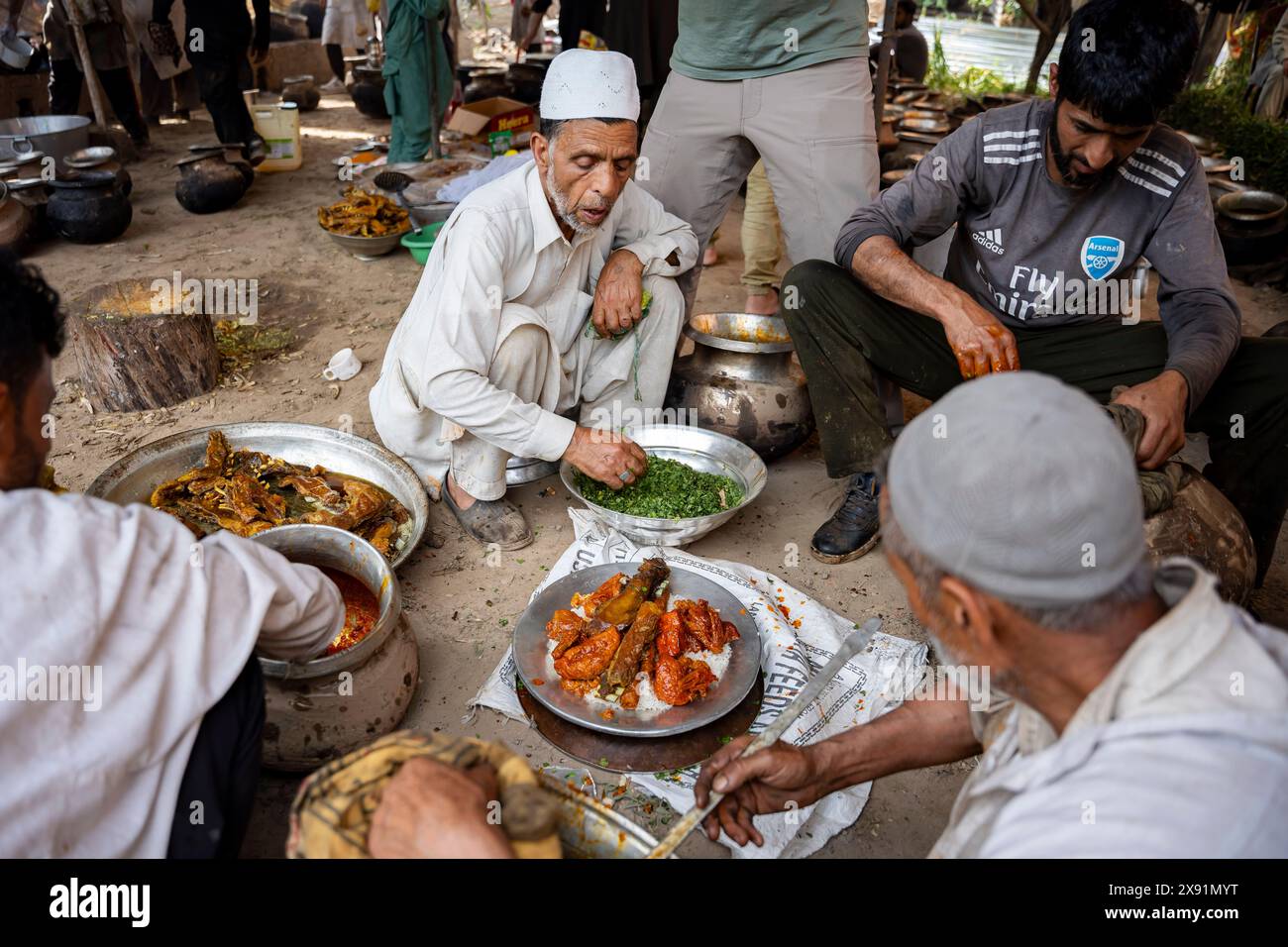 A traditional Kashmiri chef prepares a copper platter (trami) with ...