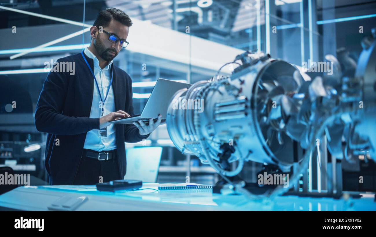 Chief Engineer Using Laptop Computer, Analyzing and Researching How a ...