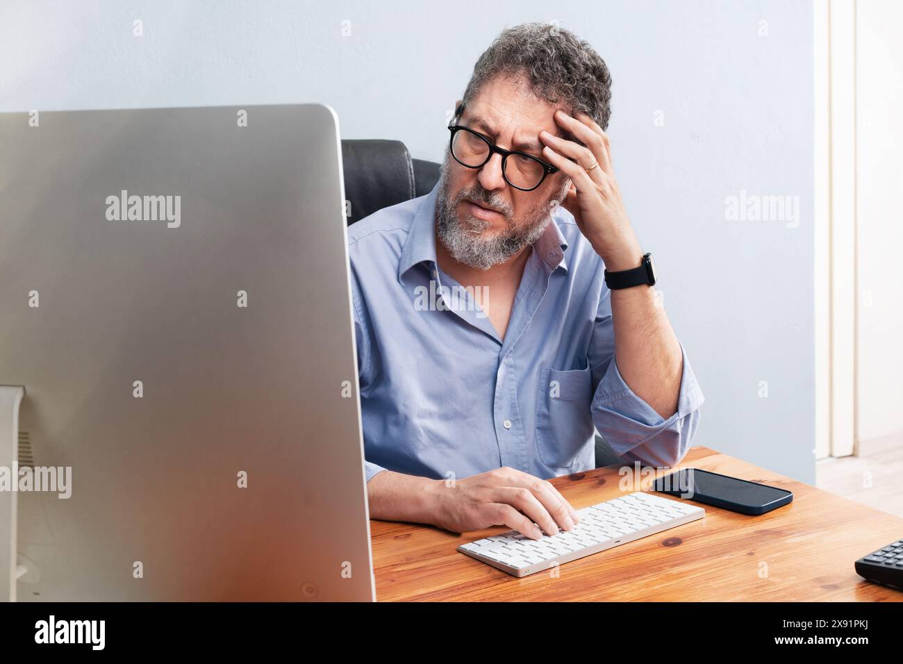 Professional businessman looking stressed while working at a computer ...