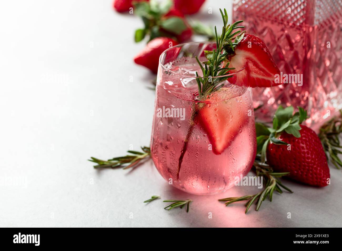 Refreshing drink with natural ice, strawberries, and rosemary in a ...