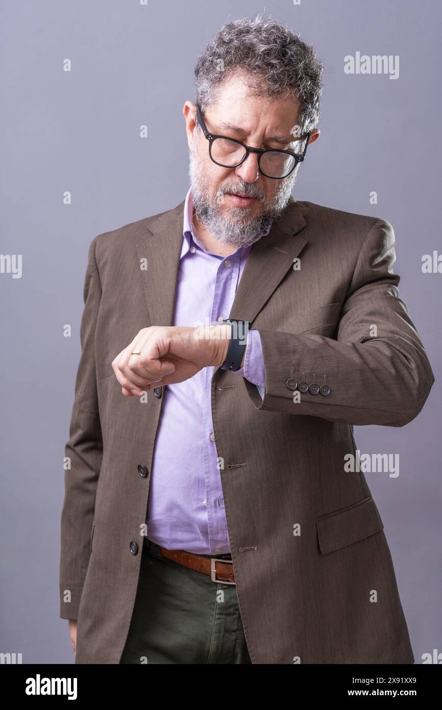Professional businessman wearing a suit and glasses, checking his ...