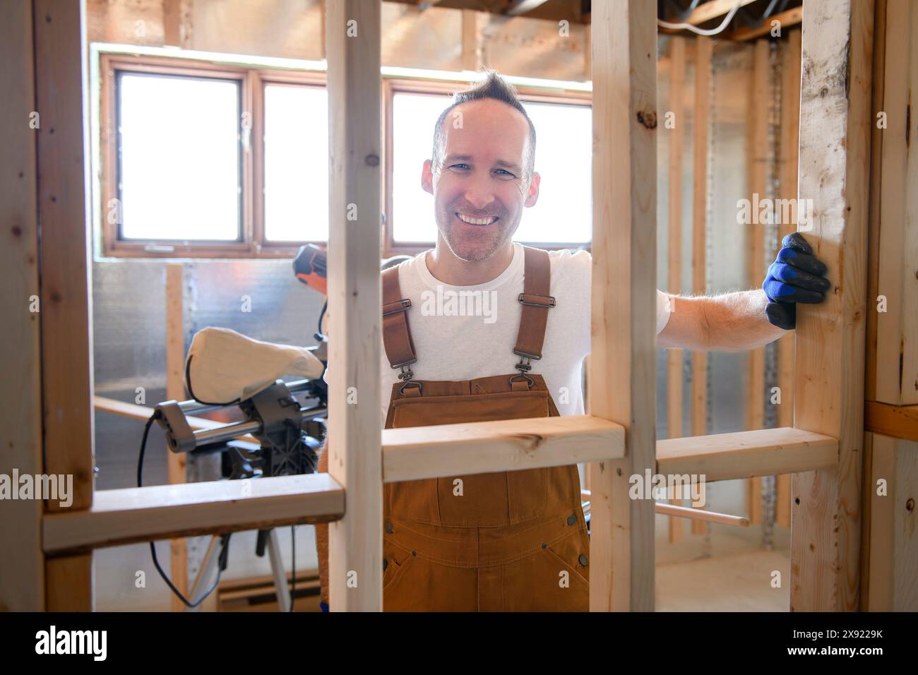 Construction Worker Using Power Tool in Unfinished Basement of New Home ...