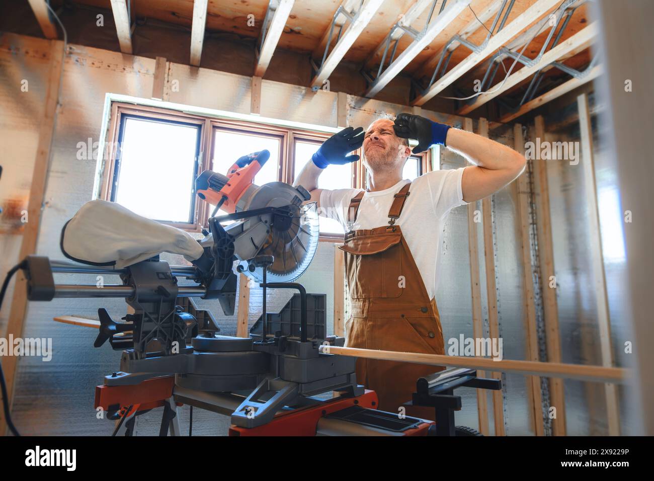 Construction Worker Using Power Tool in Unfinished Basement of New Home ...