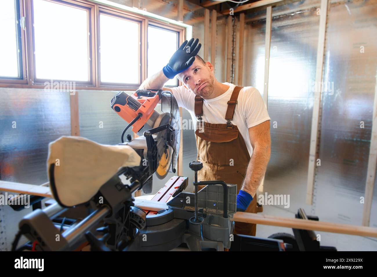 Construction Worker Using Power Tool in Unfinished Basement of New Home ...