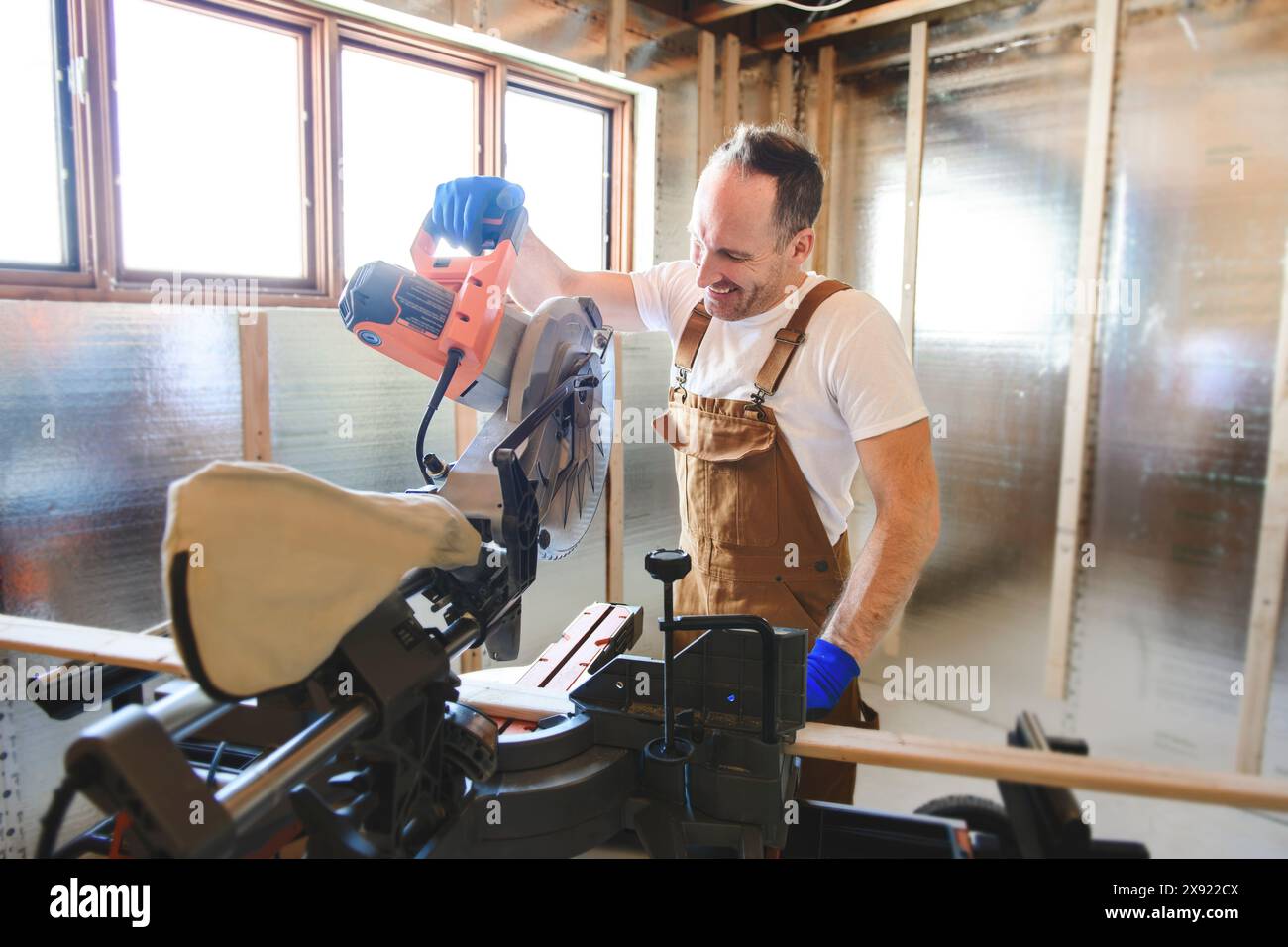 Construction Worker Using Power Tool in Unfinished Basement of New Home ...