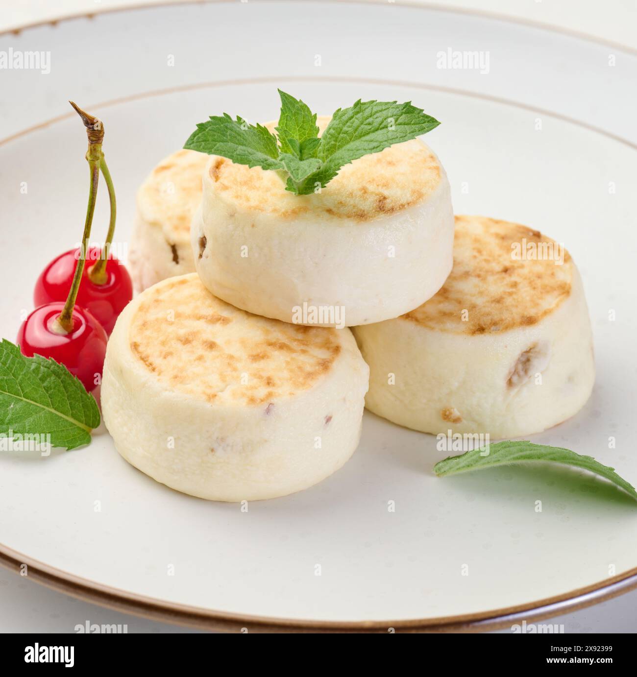 Round small fried cheesecakes on a plate. Background white Stock Photo ...