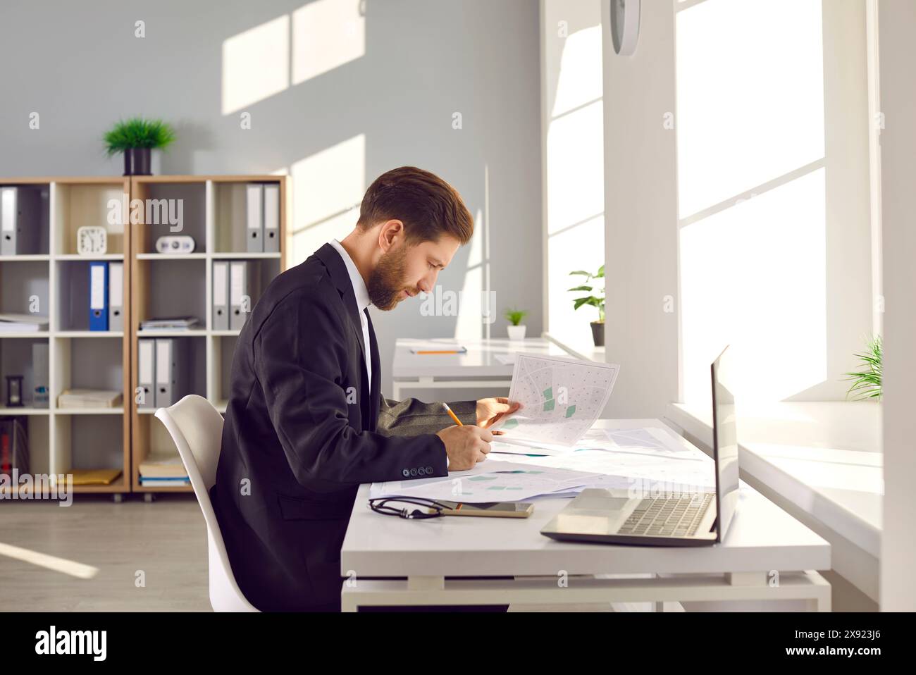 Architect working in office, using city maps and developing new ...