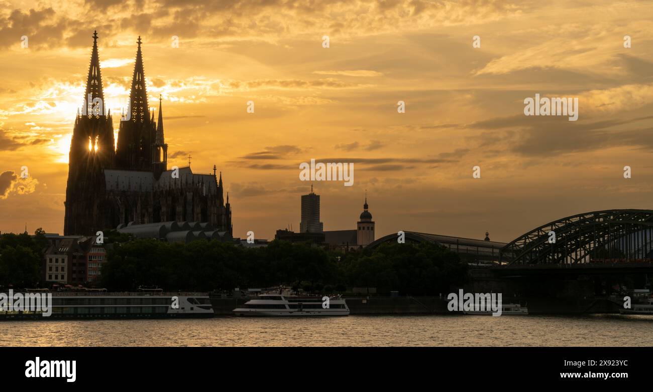 Sunset behind the twin gothic spires of Cologne Cathedral along side ...