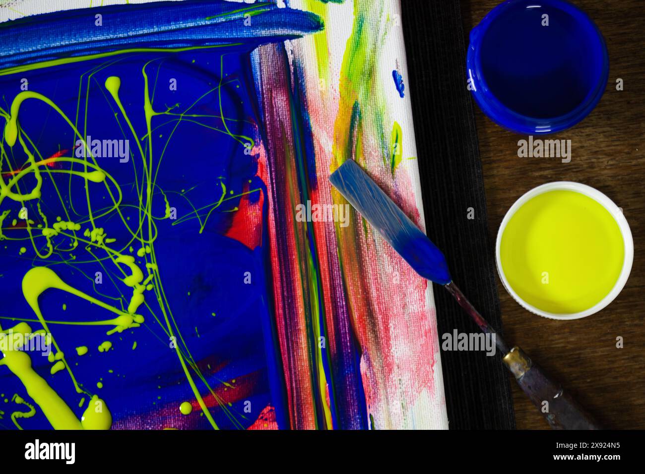 An up-close look at a female artist's workspace with vibrant paint ...