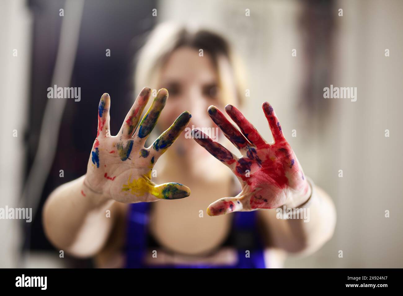 Focused shot of a female artist in a studio, displaying her colorful ...
