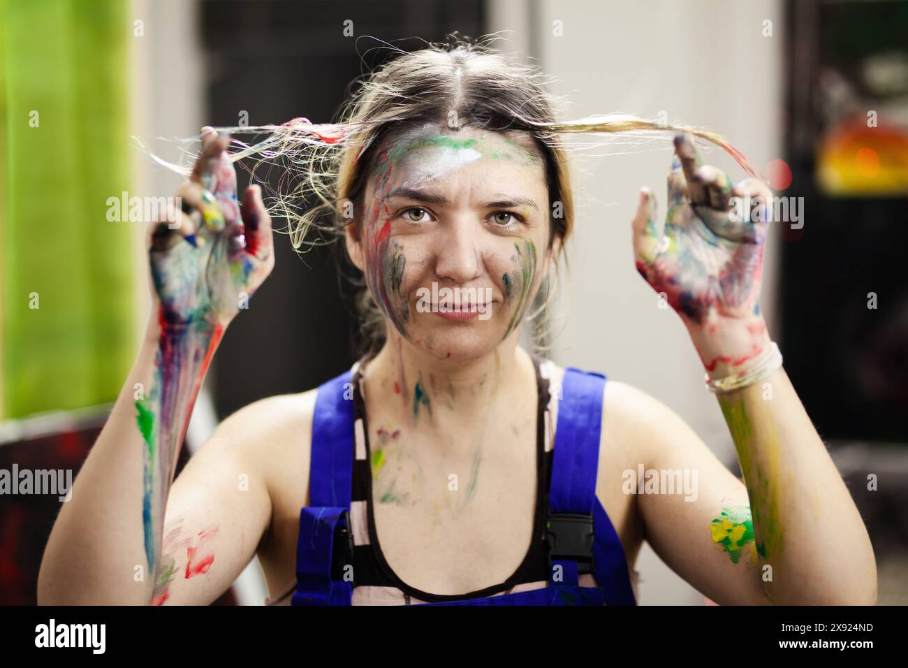 Portrait of a female artist. Girl with clumsy clorful painted face ...