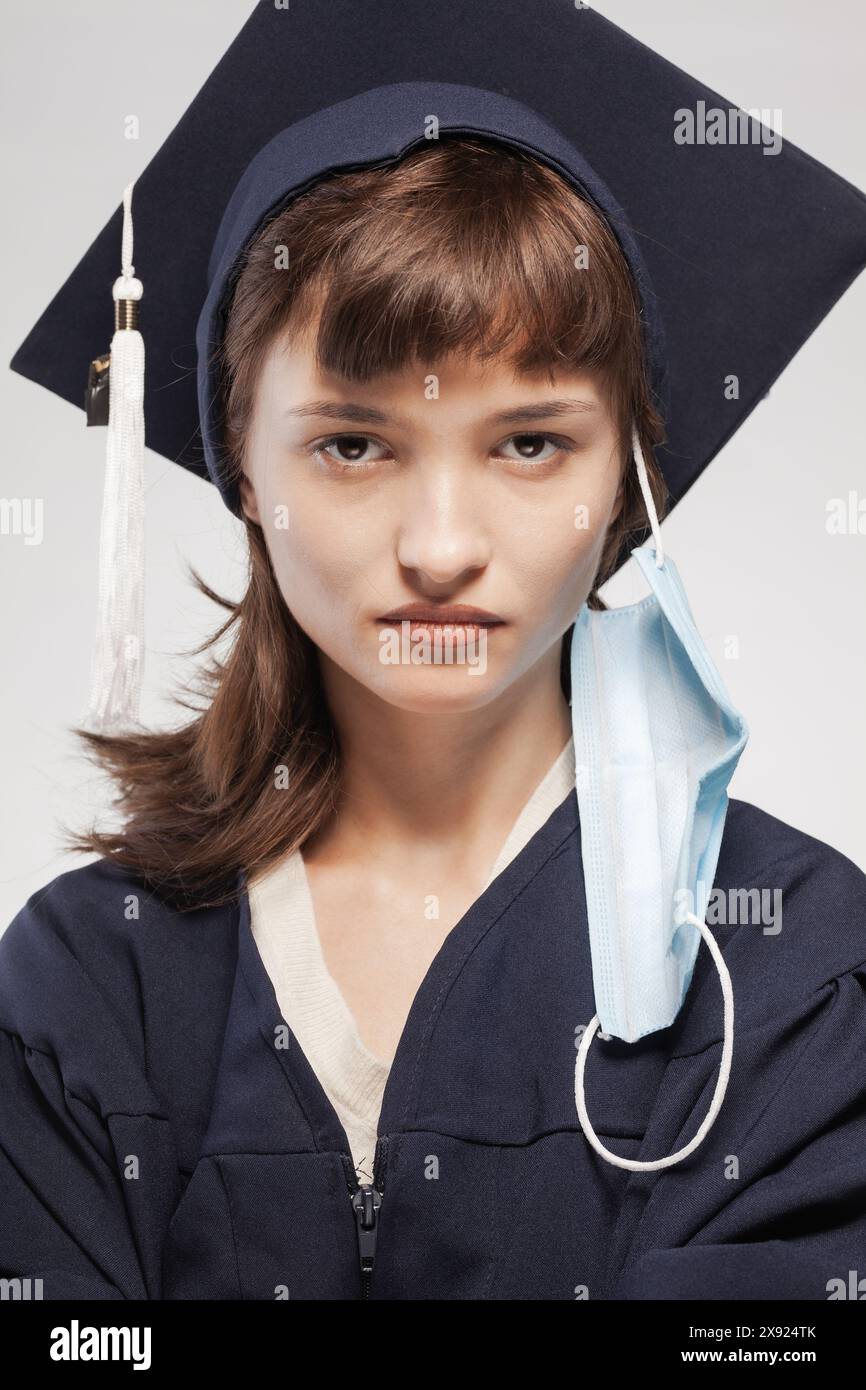 Graduation girl wearing gown and cap. Female student wearing protective ...