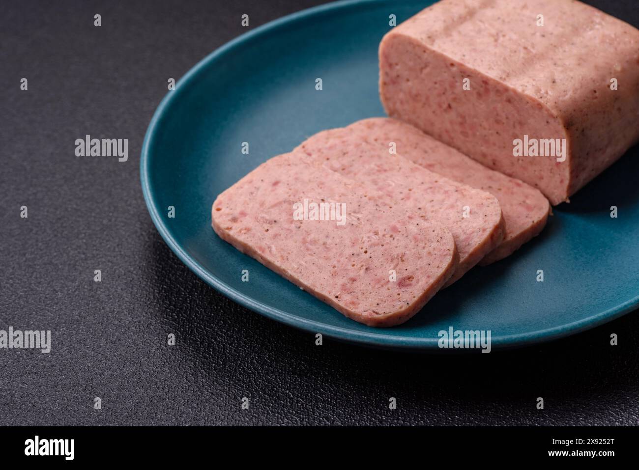 Delicious canned pink ham with salt, spices and herbs on a dark ...